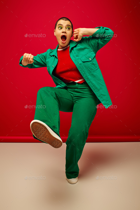 casual attire, vibrant backdrop, excited and young woman in stylish ...