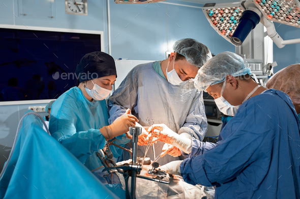 Surgeons team during complex surgical operation in a sterile operating ...