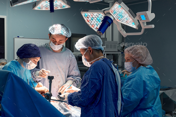 Surgeons team during complex surgical operation in a sterile operating ...