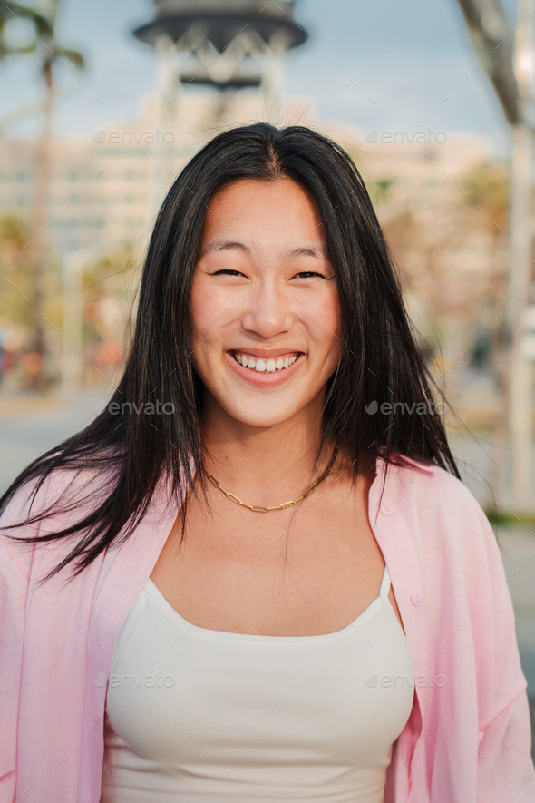 Vertical individual portrait of happy asian young adult woman smiling ...