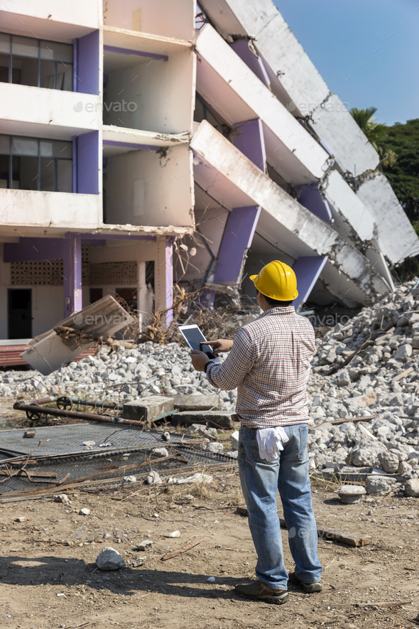 Engineer holding tablet is checking for destruction, demolishing ...