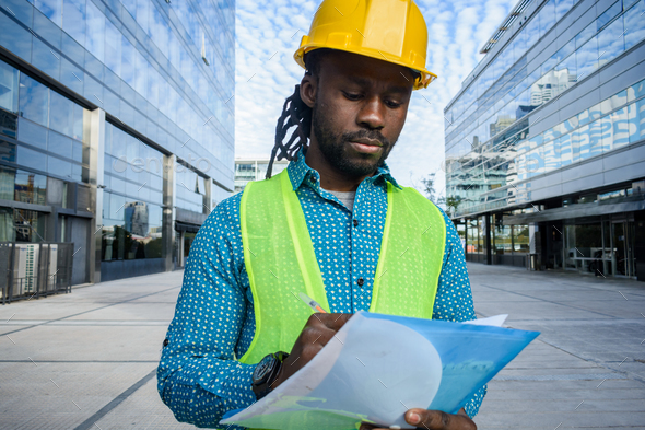 front view of african ethnicity male construction engineer thinking and ...