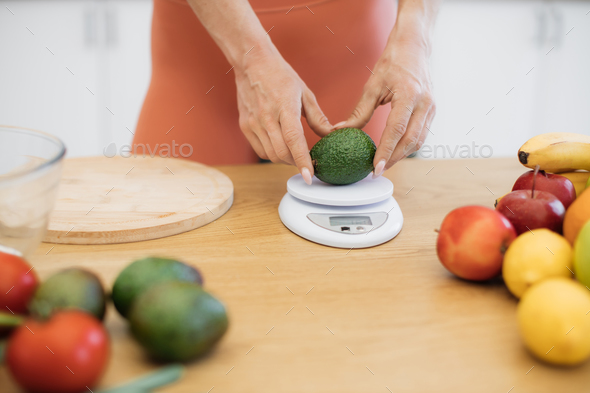 Female filming avocado on scales for video on health blog Stock Photo ...