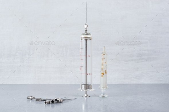 Ancient syringe with needles on gray background Stock Photo by 13people