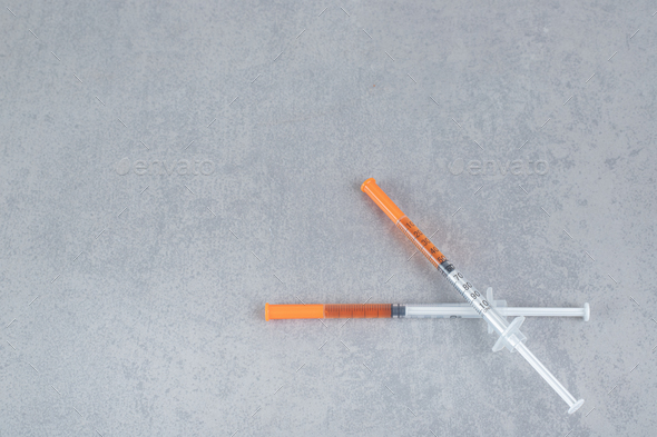Two syringes with brown liquid on gray background Stock Photo by 13people