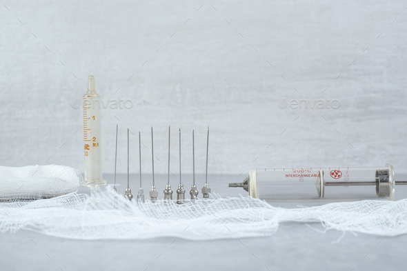 Ancient syringe with needles on gray background Stock Photo by 13people