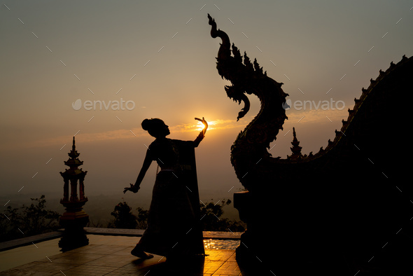 Silhouette of woman wear Thai traditional dress and stand with Thai ...