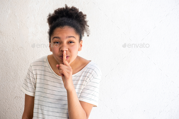 African American girl doing shh hand sign over lips with finger Stock ...