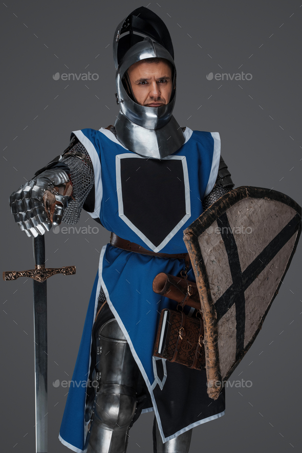 Valiant medieval warrior wearing armor and blue surcoat Stock Photo by ...
