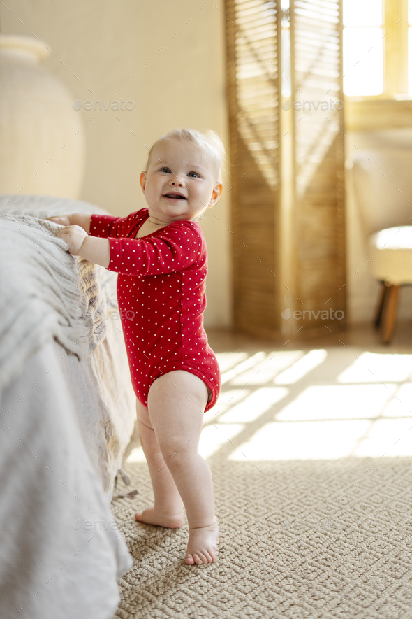 Portrait of cute little toddler wearing red baby clothes standing Stock ...