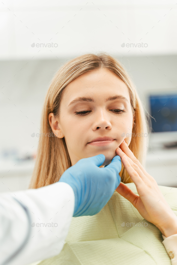 Female patient touching cheek, feeling toothache, waiting for ...