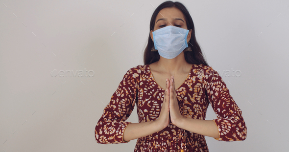 Young Indian woman with long brown hair showing Namaste greeting sign ...