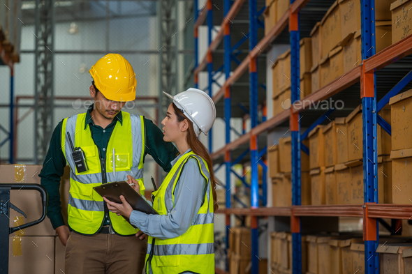 Warehouse worker checking and loading or unloading boxes in a large ...