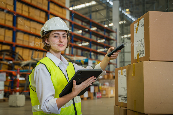 Warehouse worker checking and loading or unloading boxes in a large ...