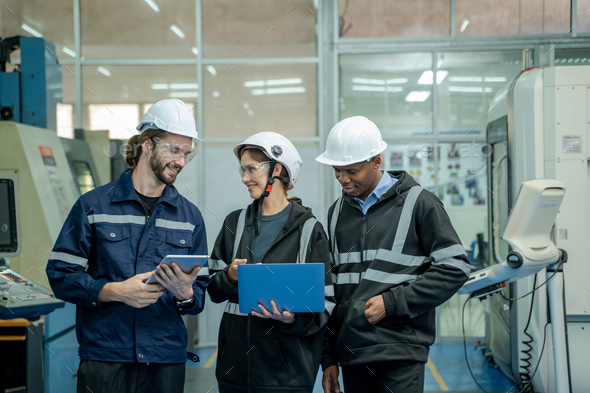 Engineer using laptop computer controlling automated robot hand with ...