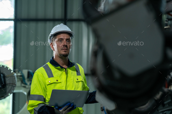 Employees are working at factory with robotic arms,Inspector equipment ...
