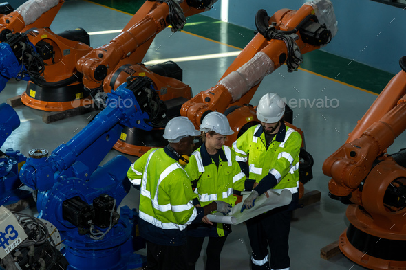 Robotics engineers inspect and maintain spare parts of industrial robot ...