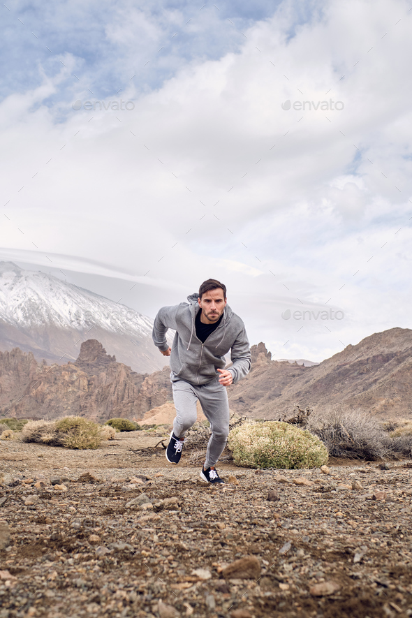 Concentrated man running on countryside road in highlands Stock Photo ...