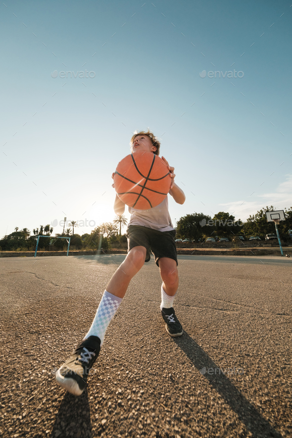 Active boy throwing ball in hoop during training Stock Photo by ...