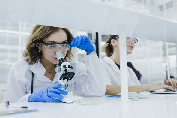 scientist using microscope at laboratory Stock Photo by khwanchai14