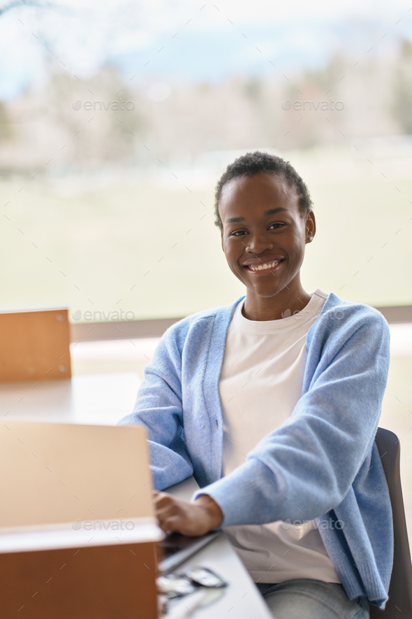 Smiling African Black girl student using laptop computer, vertical ...