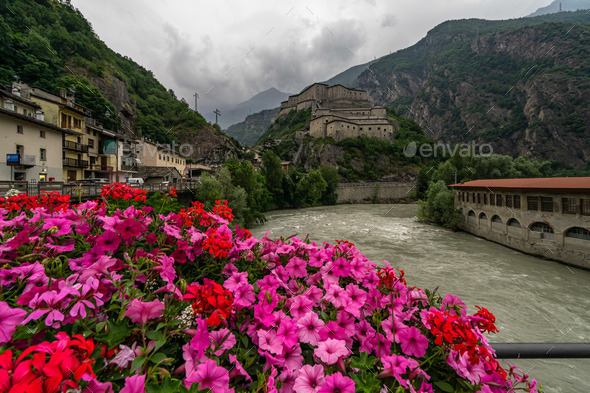 Bright red and pink petunia flowers in front of Fort Bard, Aosta Valley ...