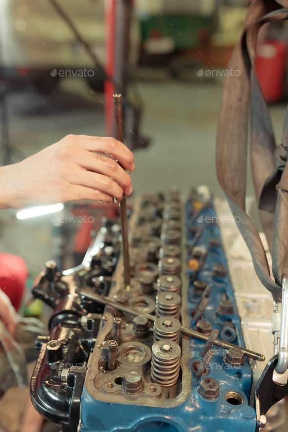 Vertical closeup shot of a mechanic mounting the car engine Stock Photo ...