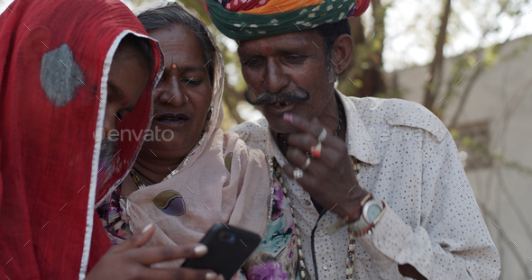 Group of South Asian people in traditional Indian clothing looking at a ...