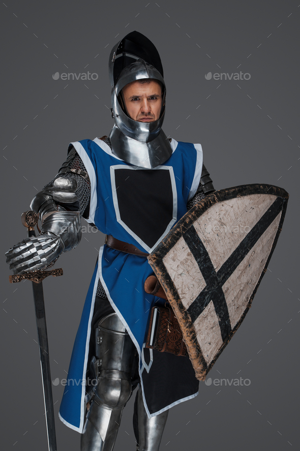 Valiant medieval warrior wearing armor and blue surcoat Stock Photo by ...