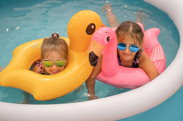 Funny beautiful pretty girls are swimming in a small inflatable rubber ...