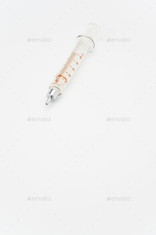 isolated sterilized glass injection syringe on a white paper background ...