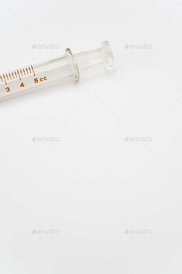 isolated sterilized glass injection syringe on a white paper background ...
