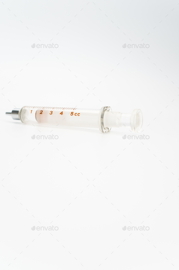 isolated sterilized glass injection syringe on a white paper background ...