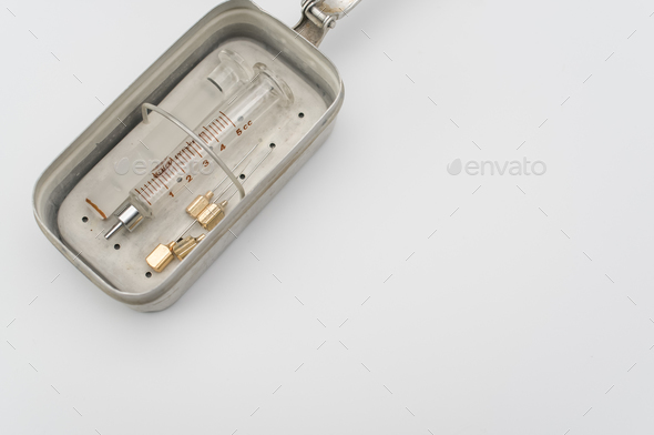 isolated sterilized glass injection syringe in a box on a white paper ...