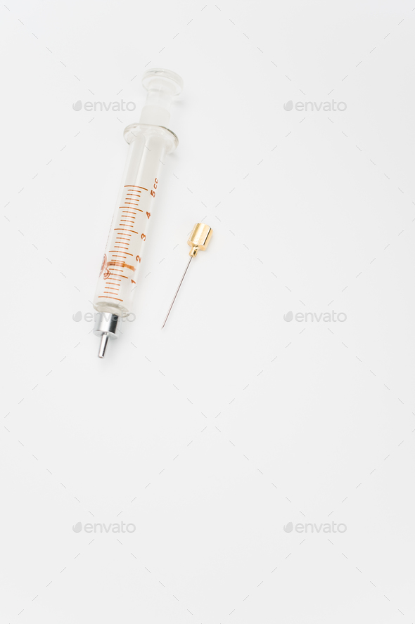 isolated sterilized glass injection syringe on a white paper background ...