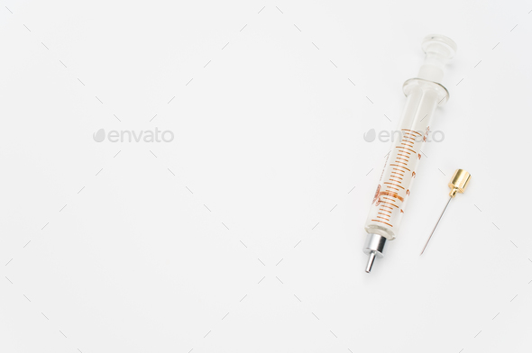 isolated sterilized glass injection syringe on a white paper background ...