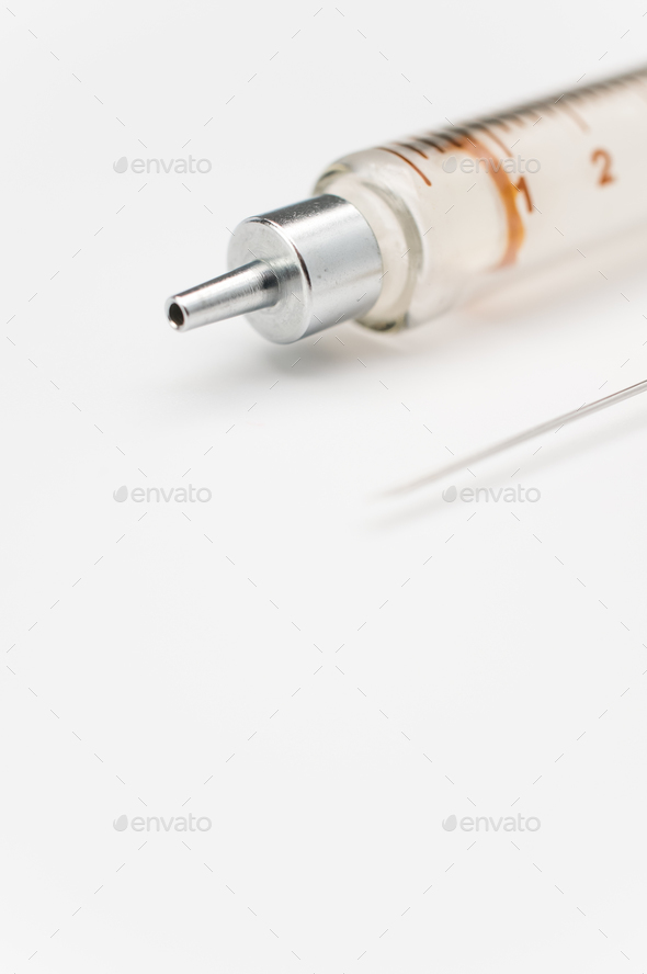 isolated sterilized glass injection syringe on a white paper background ...