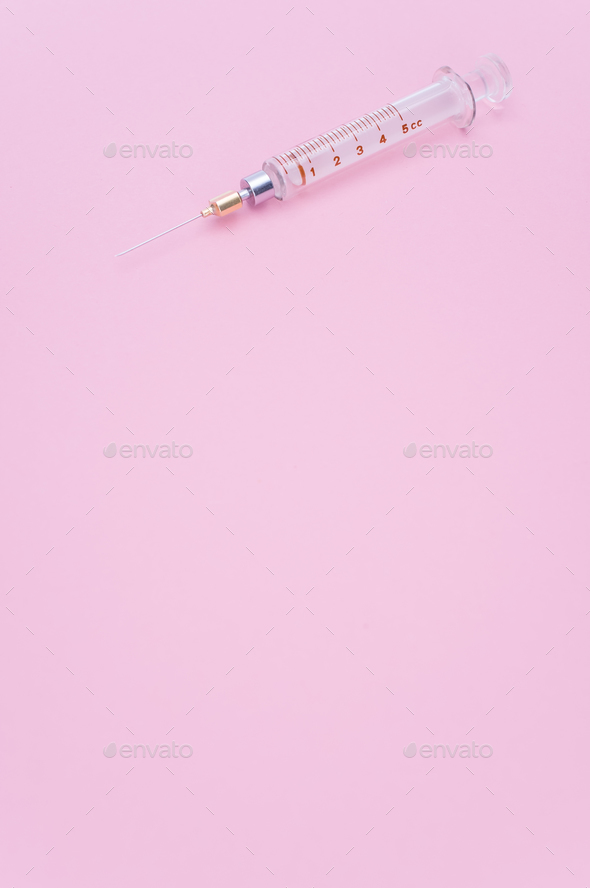 isolated sterilized glass injection syringe on a lilac paper background ...
