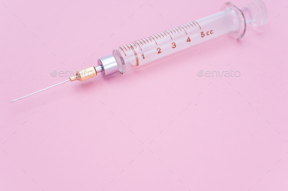 isolated sterilized glass injection syringe on a lilac paper background ...