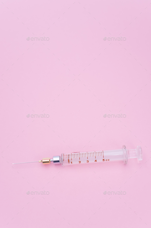 isolated sterilized glass injection syringe on a lilac paper background ...