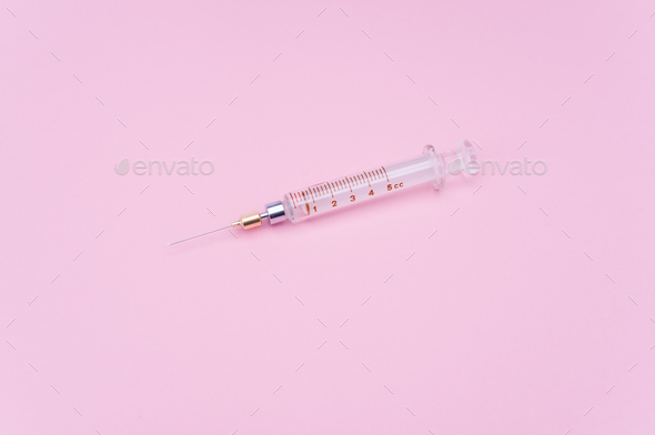 isolated sterilized glass injection syringe on a lilac paper background ...