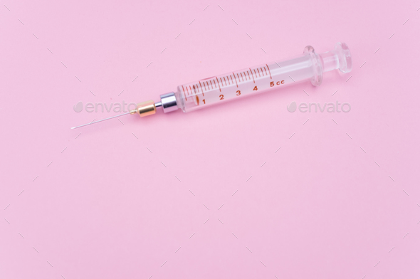 isolated sterilized glass injection syringe on a lilac paper background ...