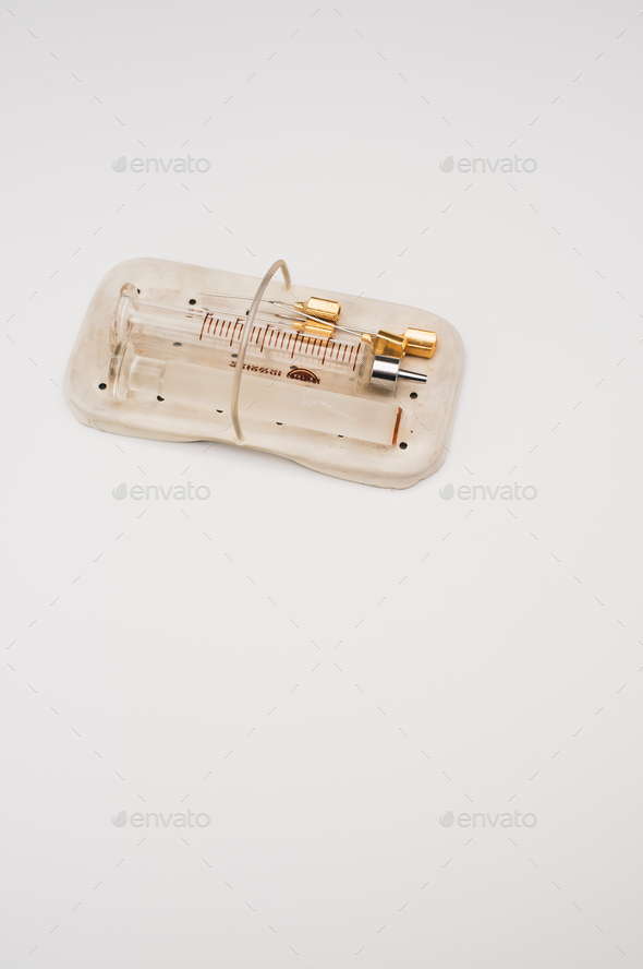 isolated sterilized glass injection syringe in a box on a white paper ...