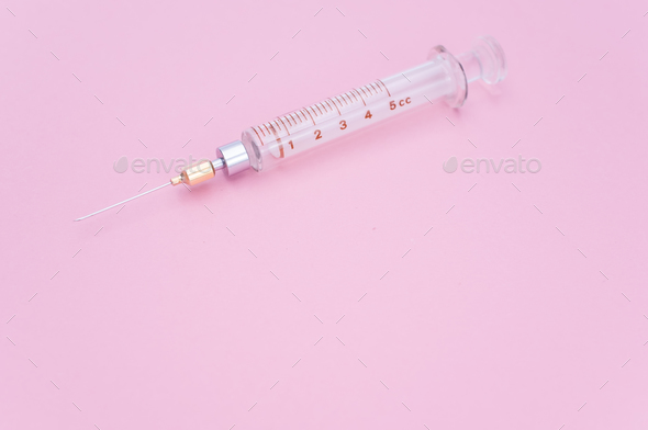 isolated sterilized glass injection syringe on a lilac paper background ...