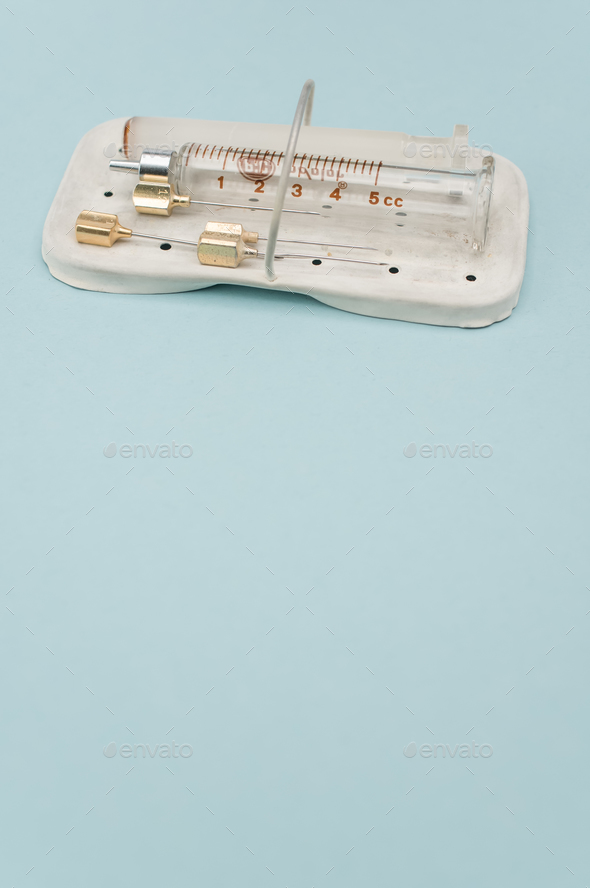 isolated sterilized glass injection syringe in a box on a blue ...