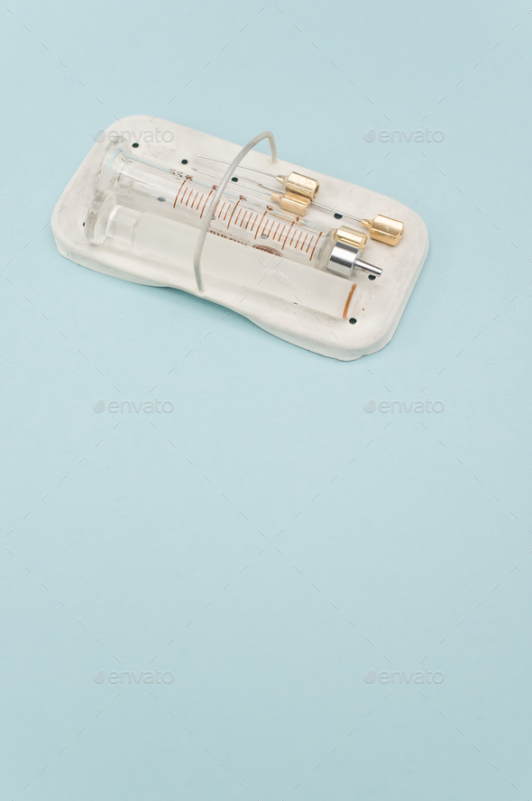 isolated sterilized glass injection syringe in a box on a blue ...