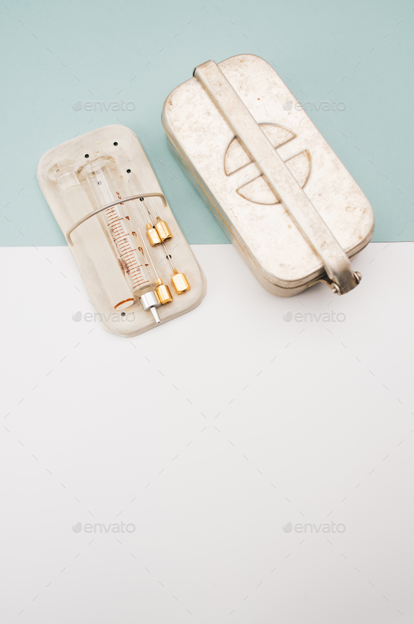 isolated sterilized glass injection syringe in a box on a blue ...