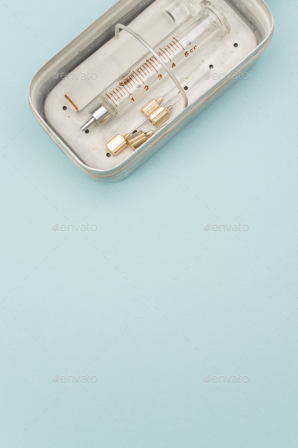 isolated sterilized glass injection syringe in a box on a blue ...