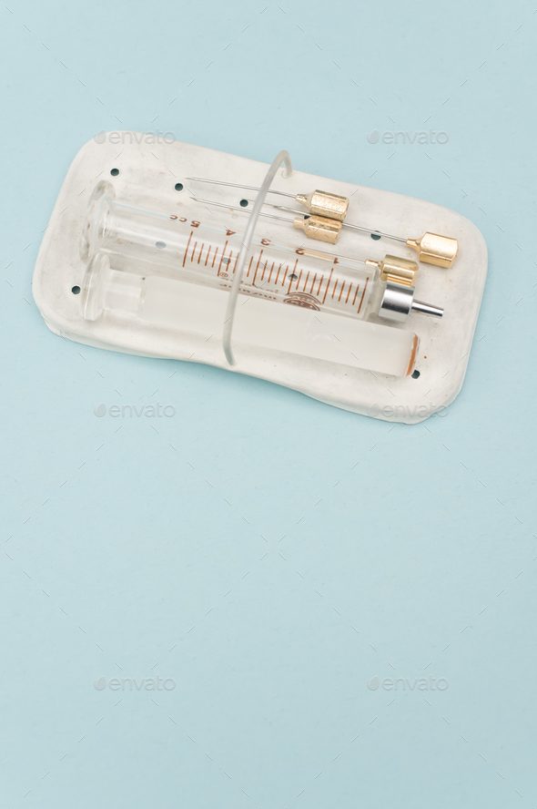 isolated sterilized glass injection syringe in a box on a blue ...