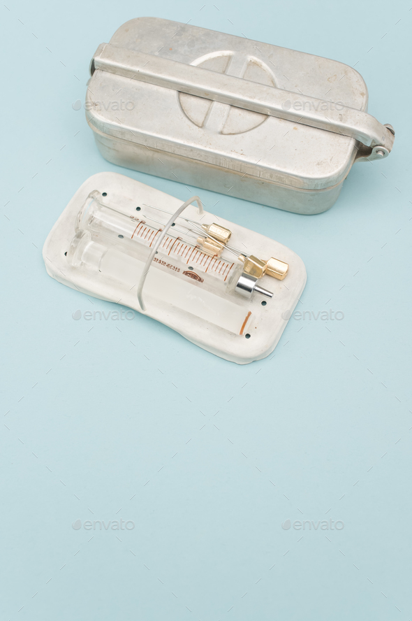 isolated sterilized glass injection syringe in a box on a blue ...